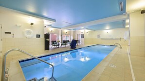 Piscina com interior azul, elevador de piscina e área acessível para cadeiras de rodas.