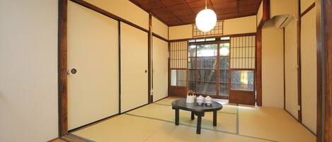 Um quarto japonês tradicional com tatames, portas deslizantes e uma mesa baixa com tatame, com um conjunto de chá.