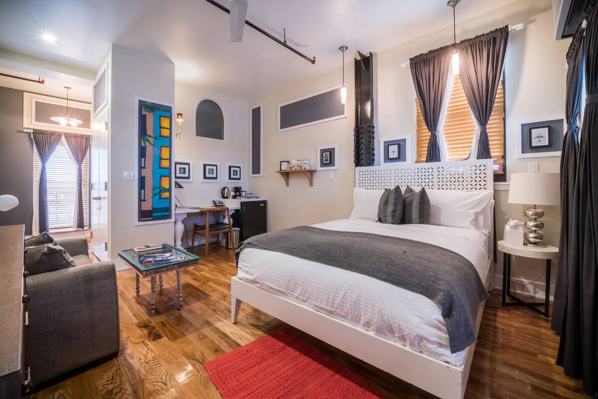 Um quarto moderno com uma cama grande, uma escrivaninha e uma cadeira.