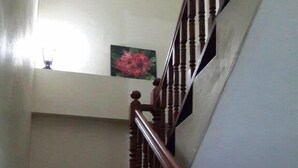Uma escadaria com corrimãos de madeira e degraus de azulejo escuro.