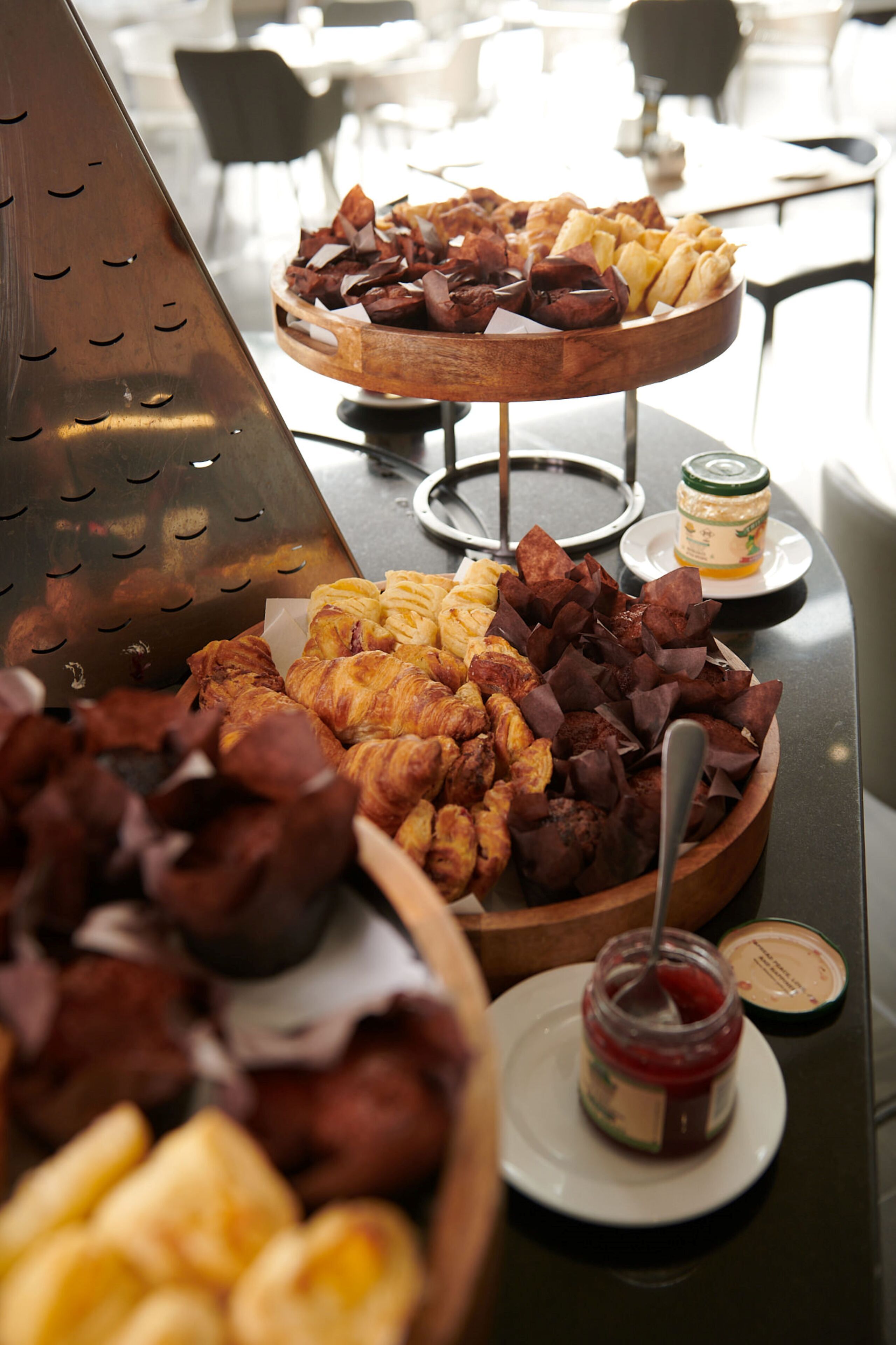 Um buffet com diversos doces e um pote de geleia.