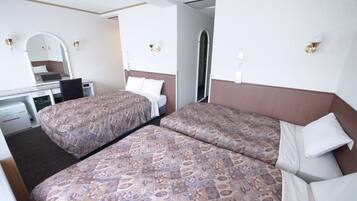 Quarto de hotel com duas camas, uma escrivaninha, uma cadeira, um espelho e um guarda-roupa.