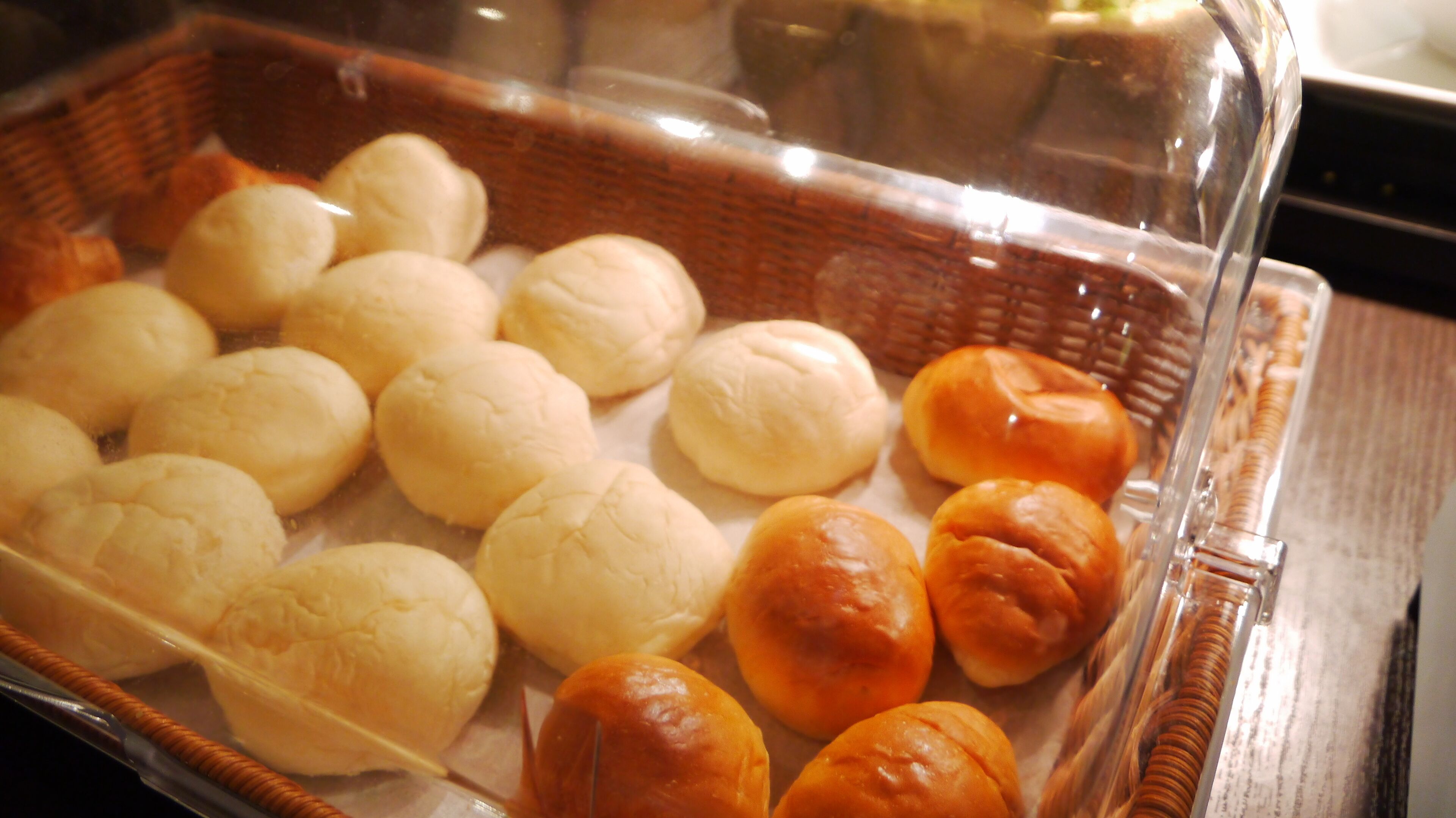Vitrine com diversos tipos de pão, incluindo pães redondos e trançados.