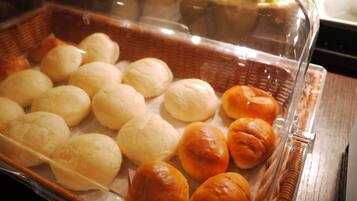 Vitrine com diversos tipos de pão, incluindo pães redondos e trançados.