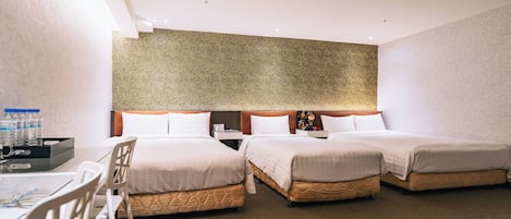 Quarto de hotel com duas camas de solteiro, uma mesinha com cadeiras e um minibar.