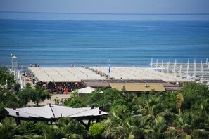 Praia particular, espreguiçadeiras, guarda-sóis, toalhas de praia