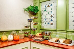 Um buffet de café da manhã com diversas opções de alimentos e bebidas.