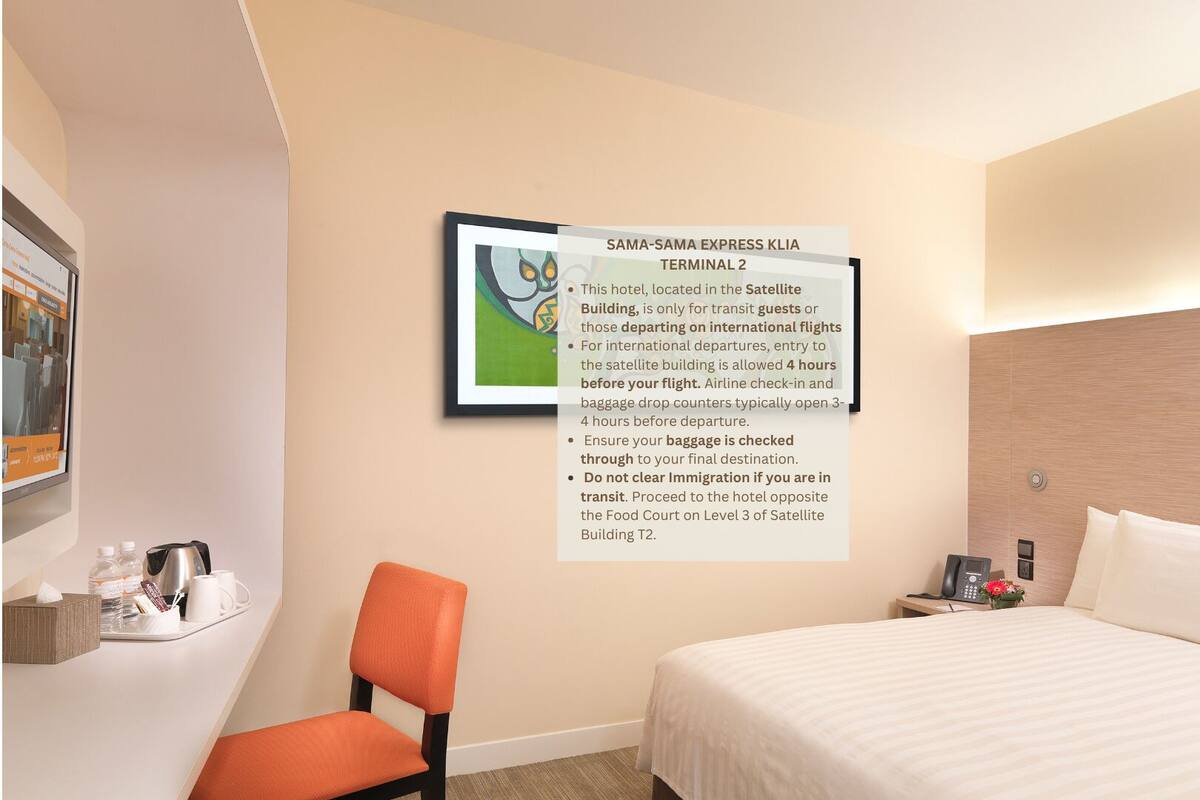 Quarto de hotel com uma cama, uma cadeira, uma mesa de cabeceira e um painel informativo fixado na parede.