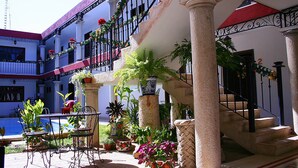Pátio com piscina, área de estar externa e escadaria com grades decorativas.