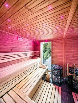 Uma sauna com bancos de madeira e aquecedor de pedra.