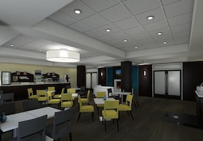 Um restaurante moderno com cadeiras amarelas, mesas brancas e um balcão central.