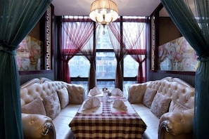Um quarto com toalha xadrez, dois sofás e um candelabro.