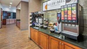 Uma estação de café com vários dispensadores e um painel de cardápio para o suco Florida's Natural.
