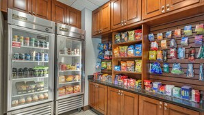 Um supermercado com seções refrigeradas e prateleiras repletas de lanches e bebidas.