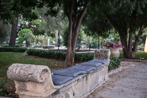 Banco de pedra com almofadas em um parque.