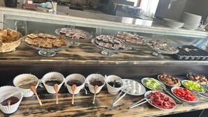 Um buffet com diversos alimentos e utensílios.