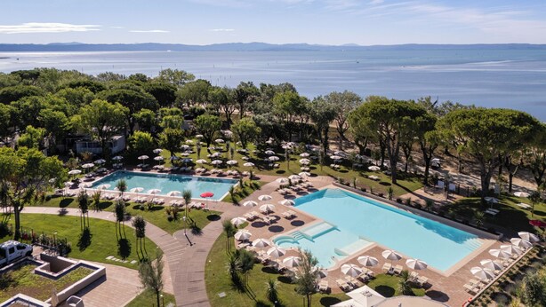 Resort com várias piscinas, espreguiçadeiras e vista para o mar.