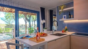 Cozinha moderna com ilha integrada, pia e janela com vista para um jardim.