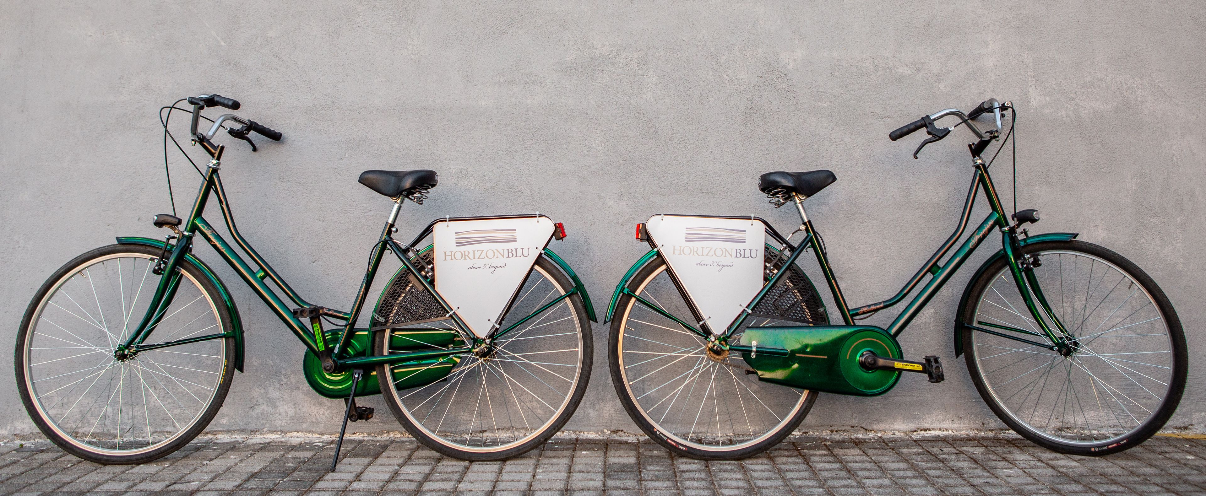 Três bicicletas apoiadas em uma parede.