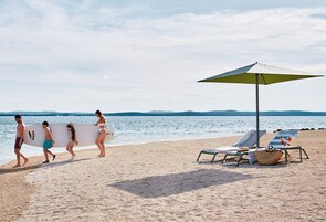 Uma praia privada, espreguiçadeiras, guarda-sóis de praia 