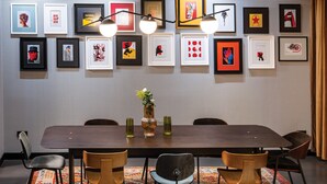 Uma sala de jantar com uma mesa comprida, seis cadeiras e um tapete estampado.