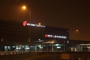 Um edifício moderno com letreiros iluminados para o hotel 'Air China' e 'Boyue'.