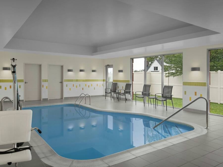 Piscina com cadeira e rampa de acesso para cadeiras de rodas.