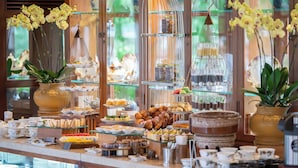 Buffet com diversos alimentos e uma vitrine de vidro com objetos decorativos.