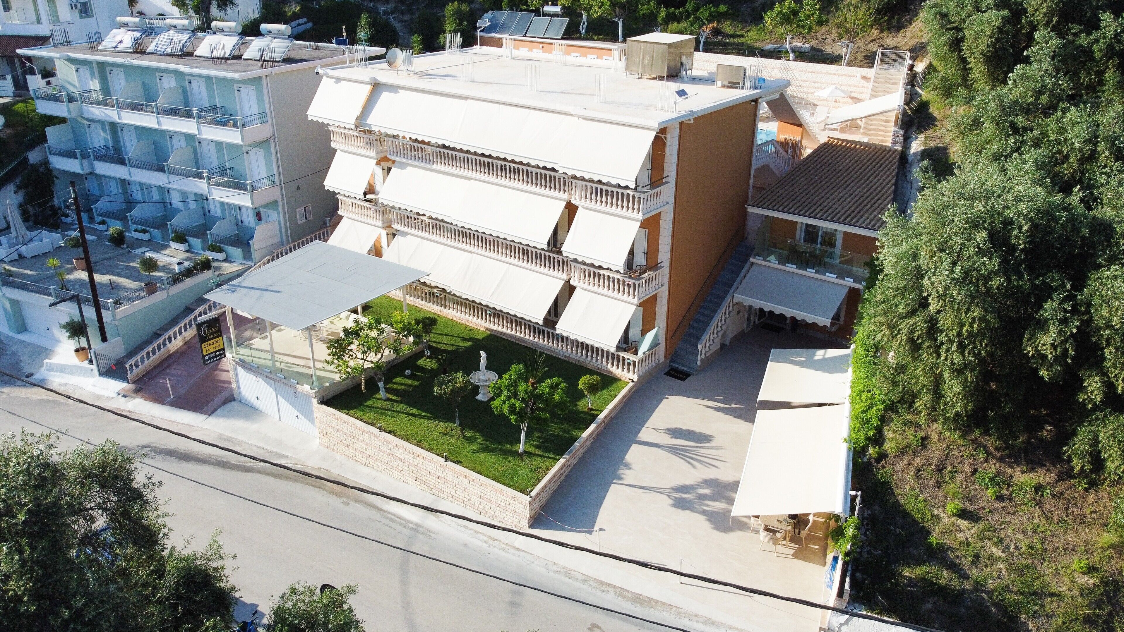 Um hotel com vários andares, varandas, piscina e painéis solares.