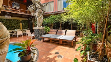Pátio com estátua, área de estar ao ar livre e piscina.