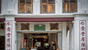 Um restaurante com uma placa que diz "BISTRO TANG" e caracteres chineses tradicionais na fachada.