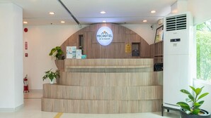 Uma receção com design em madeira, um sinal a indicar 'MICROTEL BY WYNDHAM' e um aparelho de ar condicionado grande.