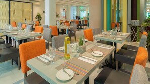 Um restaurante moderno com várias mesas, cada uma posta com pratos, talheres e copos.