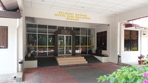 A entrada do Hotel Selamat Datang Seri Malaysia Marang, com fachada de vidro transparente e um letreiro sobre a entrada.