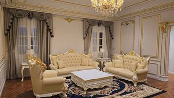 Quarto luxuoso com mobiliário requintado, incluindo um sofá com capitonê e uma mesa de centro combinando, sobre um tapete com padrão rico.
