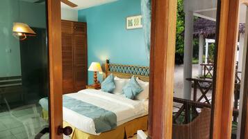 Quarto com cama, cabeceira de madeira e mesa de cabeceira com luminária.