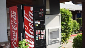 Uma máquina de venda automática de Coca-Cola com visor digital e dispensador de água.