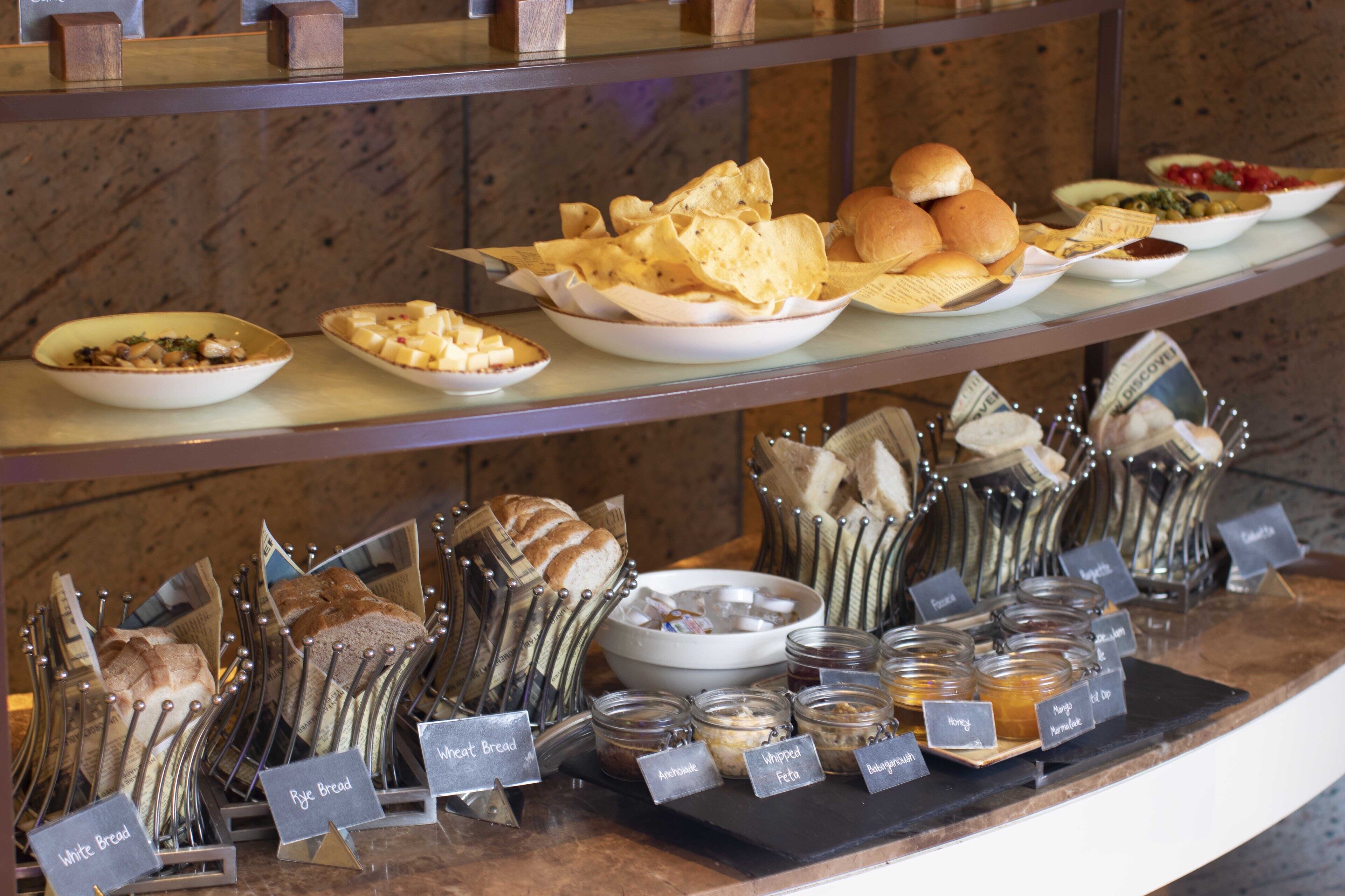 Buffet com diversos alimentos e etiquetas.