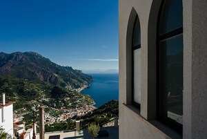 Uma vila costeira com vista para o mar e montanhas.