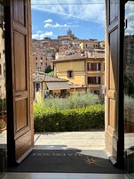 Entrada de hotel com vista para edifícios históricos e um céu limpo.
