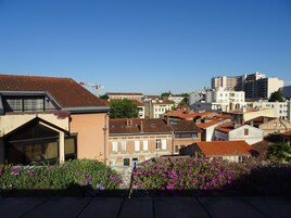 Zona residencial com mistura de arquitetura moderna e tradicional, apresentando diversos estilos de construção e cores de telhado.