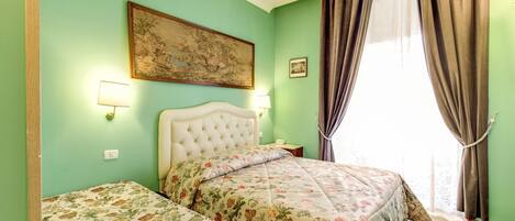 Quarto com uma cama, duas mesas de cabeceira, uma luminária na parede e uma janela com cortinas.