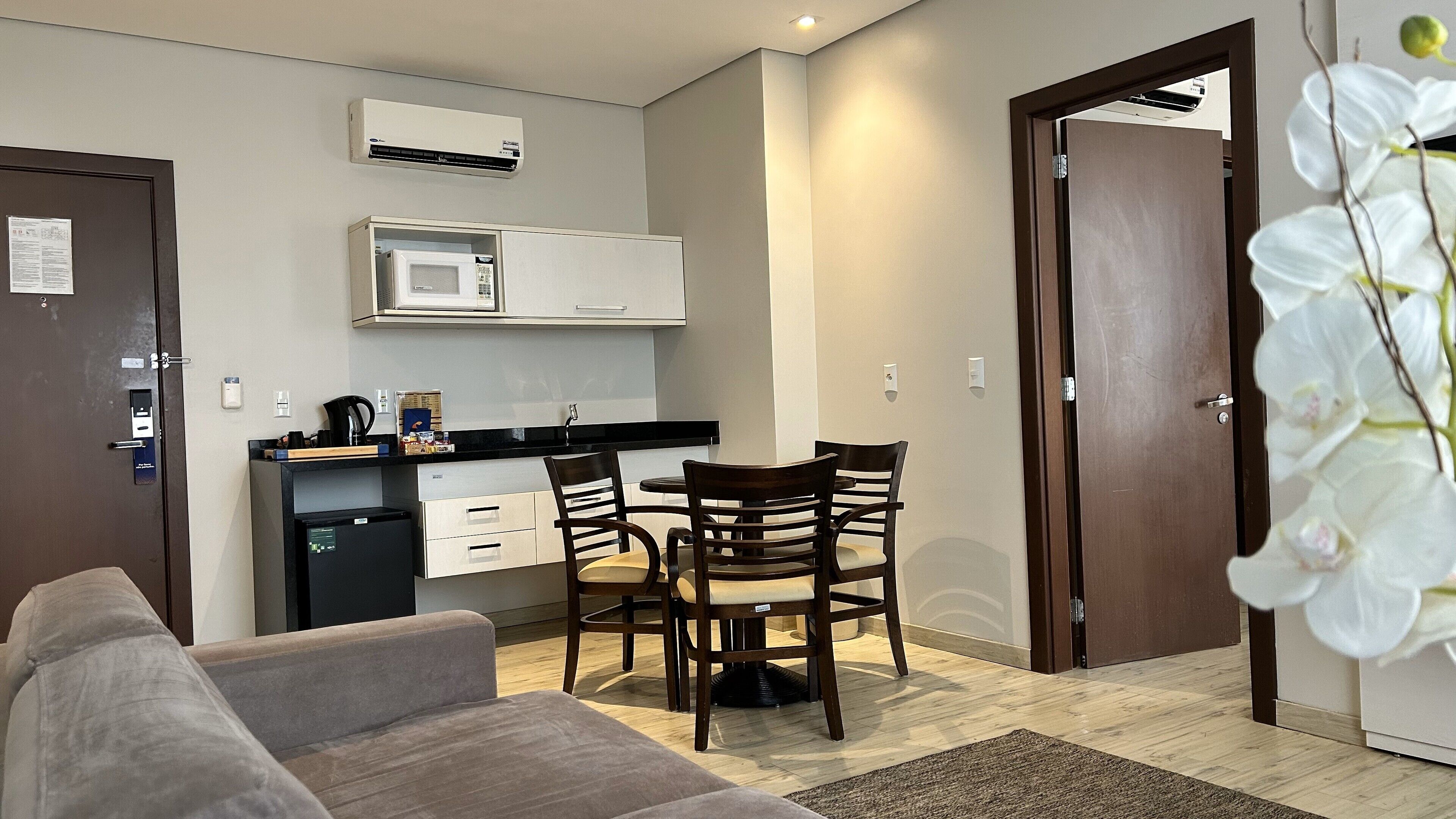 Um espaço compacto com cozinha compacta, área de refeições e sofá.