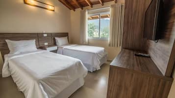 Quarto com duas camas, teto de madeira, televisão na parede e janela com cortinas.