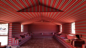 Um quarto com paredes listradas e um banco ao longo das paredes.