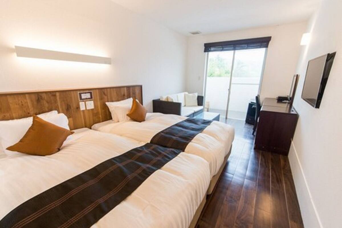 Quarto de hotel com uma cama grande, uma escrivaninha e vista para o exterior.