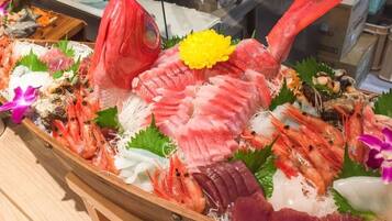 Uma seleção de frutos do mar com diversos tipos de peixe e camarão, decorada com flores.