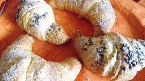 Quatro croissants sobre um tecido estampado em laranja.