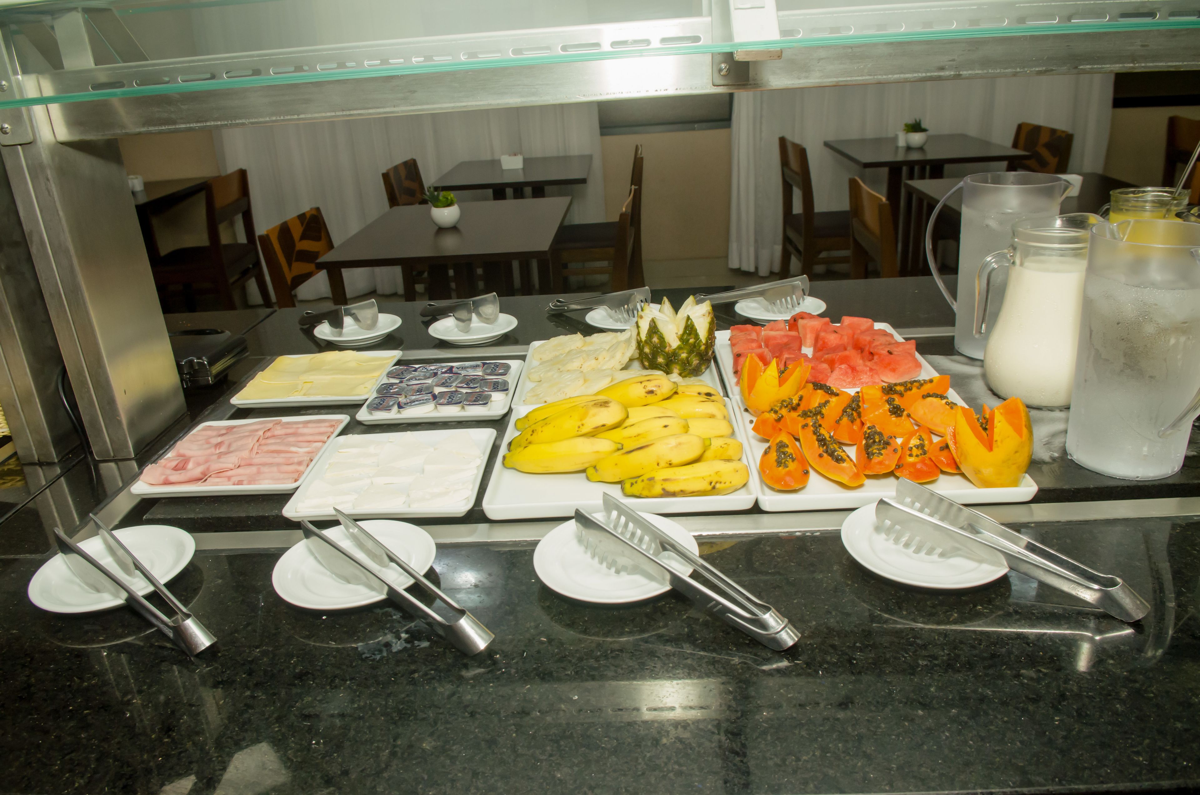 Um buffet com diversos alimentos e utensílios.