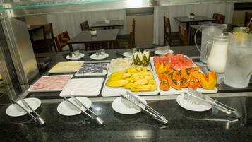 Um buffet com diversos alimentos e utensílios.
